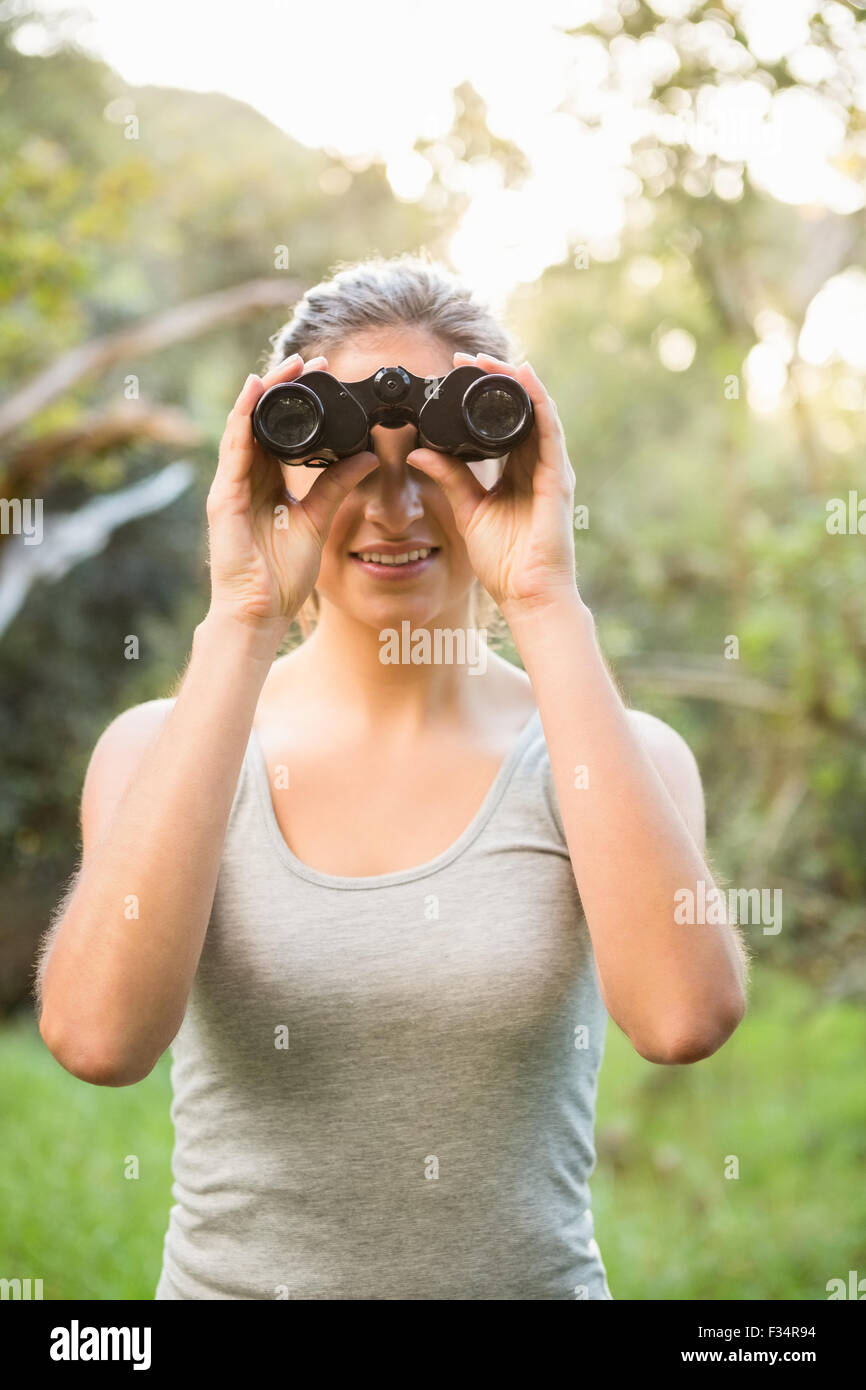 Smiling pretty brunette looking through binoculars Stock Photo - Alamy