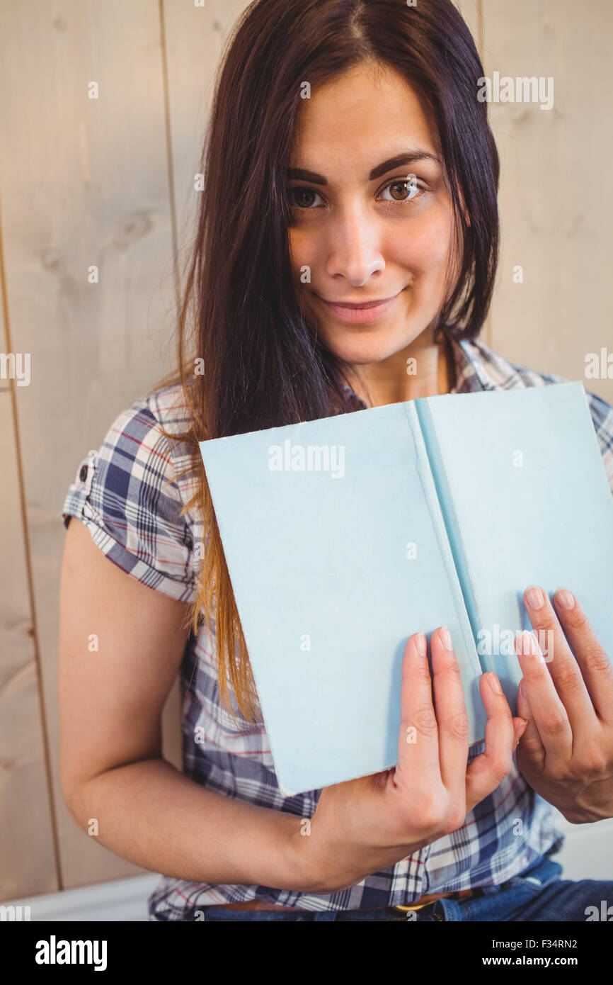 Pretty hipster reading blue book Stock Photo - Alamy
