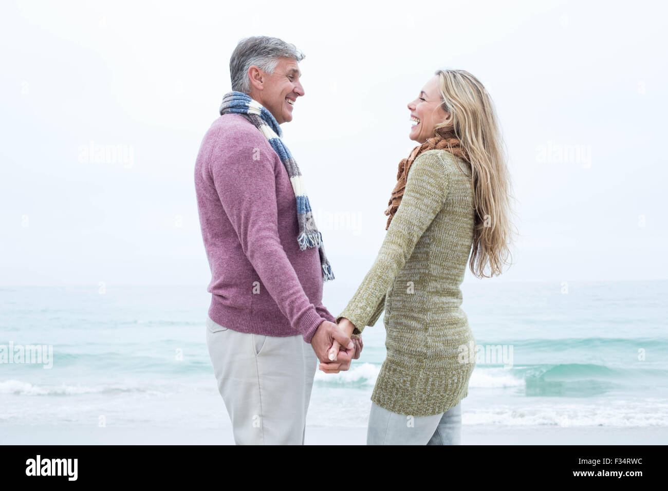 Happy couple standing holding each others hands Stock Photo - Alamy