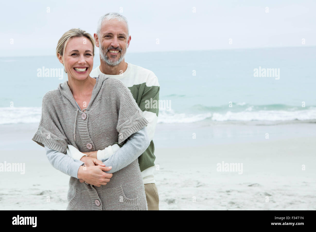 Smiling couple holding hands and hugging Stock Photo - Alamy
