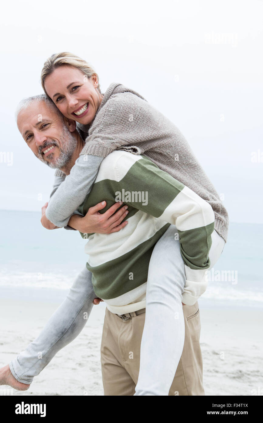 Man giving his partner a piggy back Stock Photo - Alamy