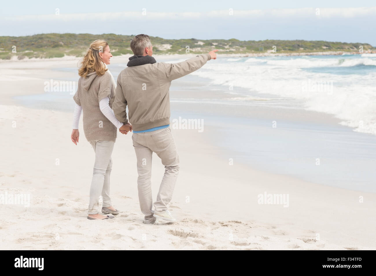 Happy couple holding hands while walking Stock Photo - Alamy
