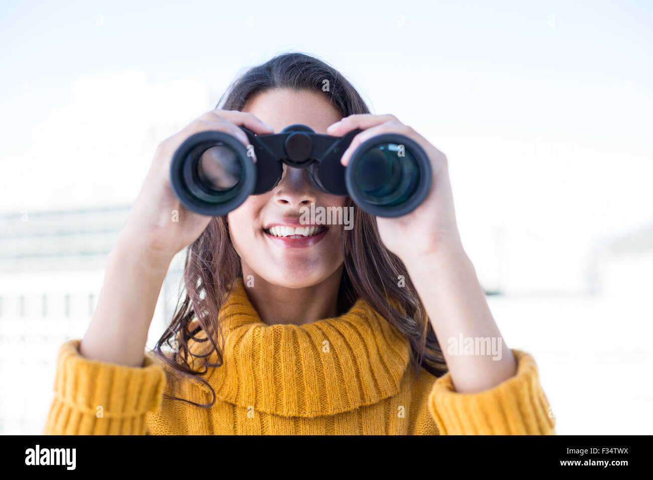 Pretty woman looking through binoculars Stock Photo - Alamy
