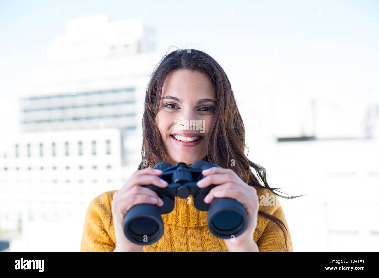 Pretty woman looking through binoculars Stock Photo - Alamy
