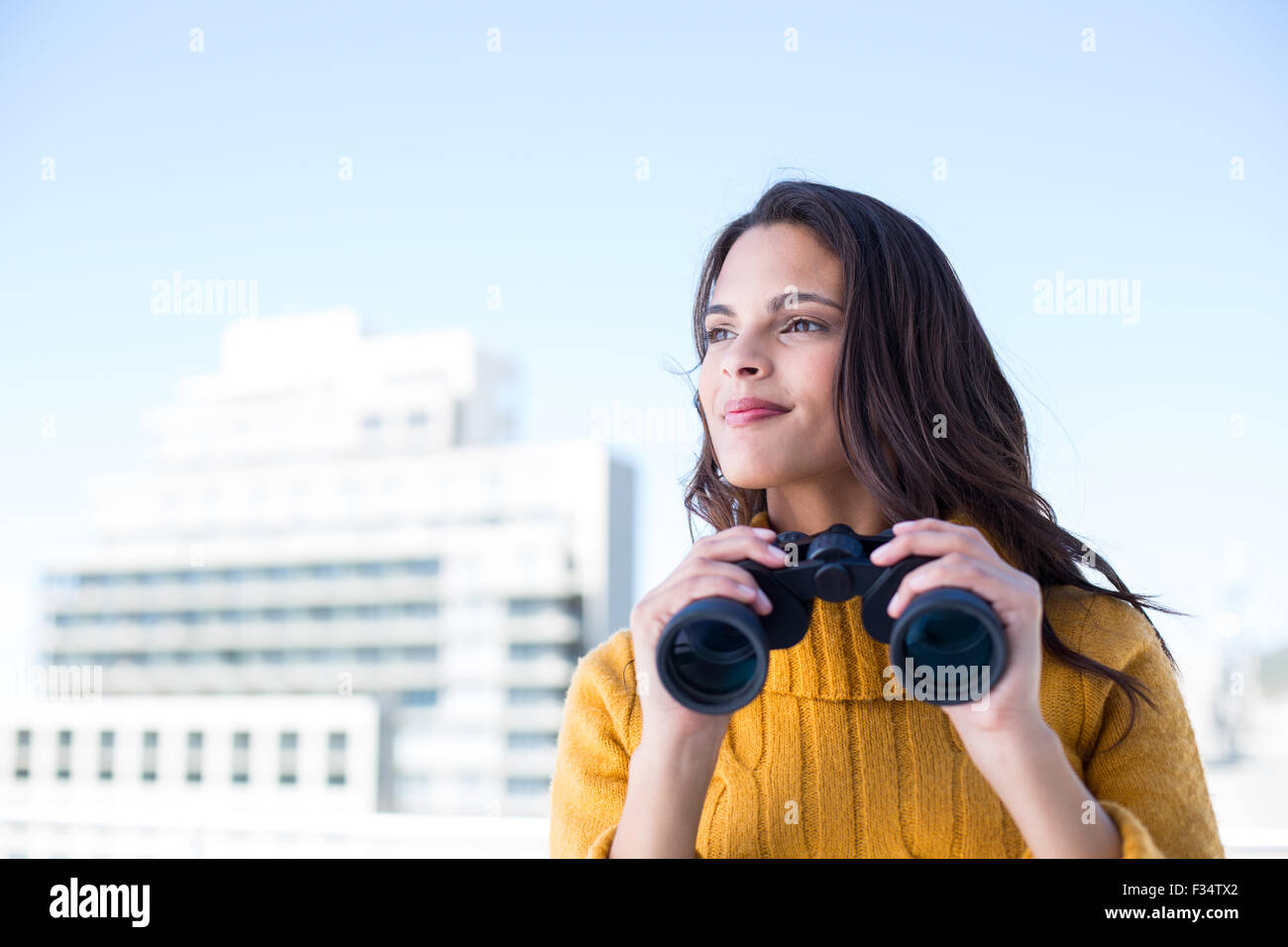 Pretty brunette holding binoculars Stock Photo - Alamy