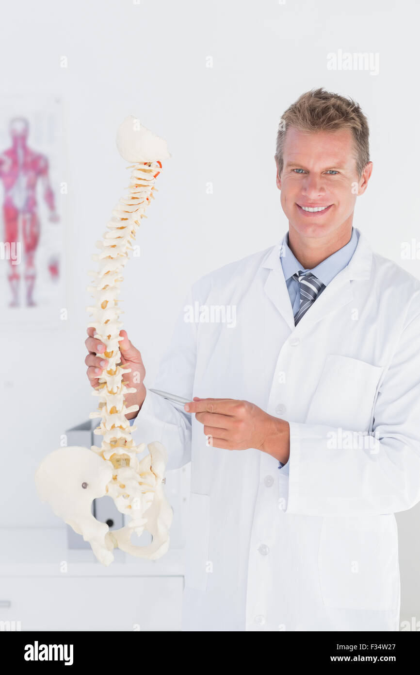 Happy doctor showing anatomical spine Stock Photo - Alamy