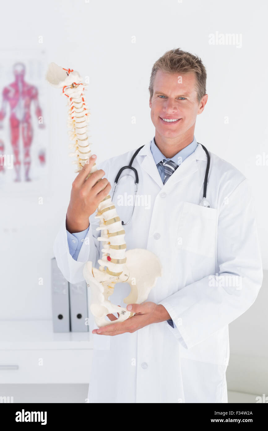 Happy doctor showing anatomical spine Stock Photo - Alamy