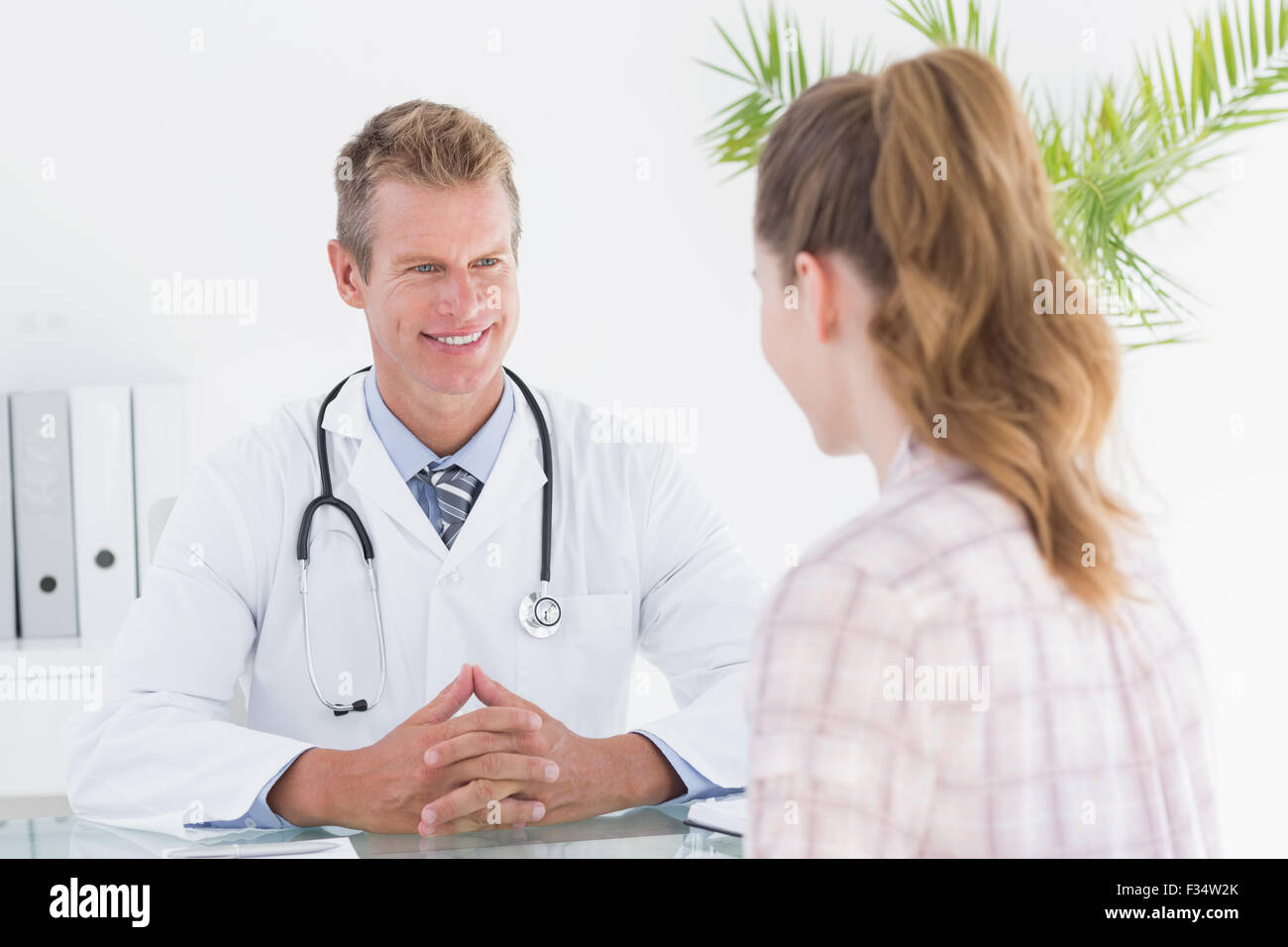 Happy doctor listening his patient Stock Photo - Alamy