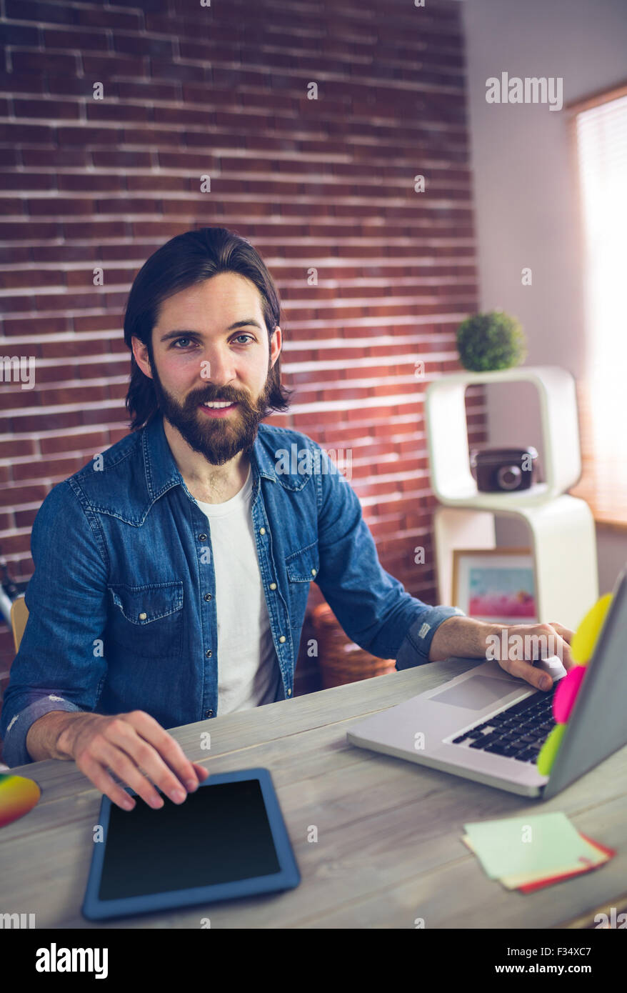 Portrait of creative businessman using graphic tablet and laptop Stock ...