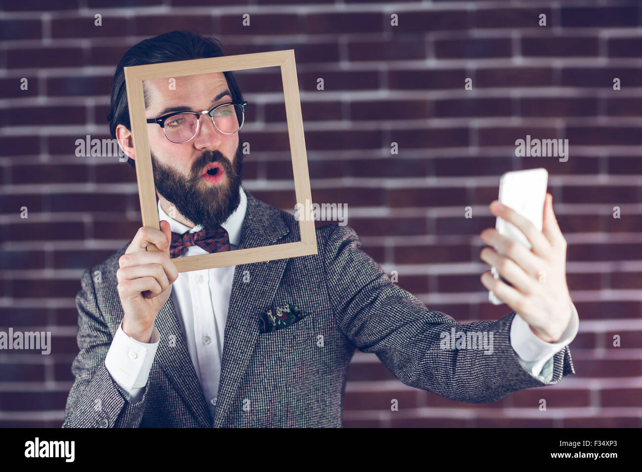 Fashionable man taking selfie while holding frame Stock Photo - Alamy