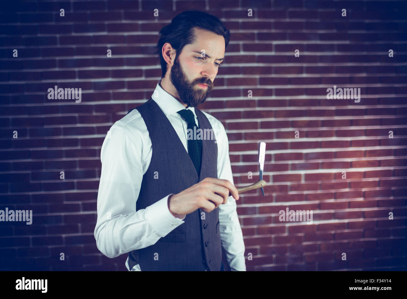 Serious man holding razor Stock Photo - Alamy