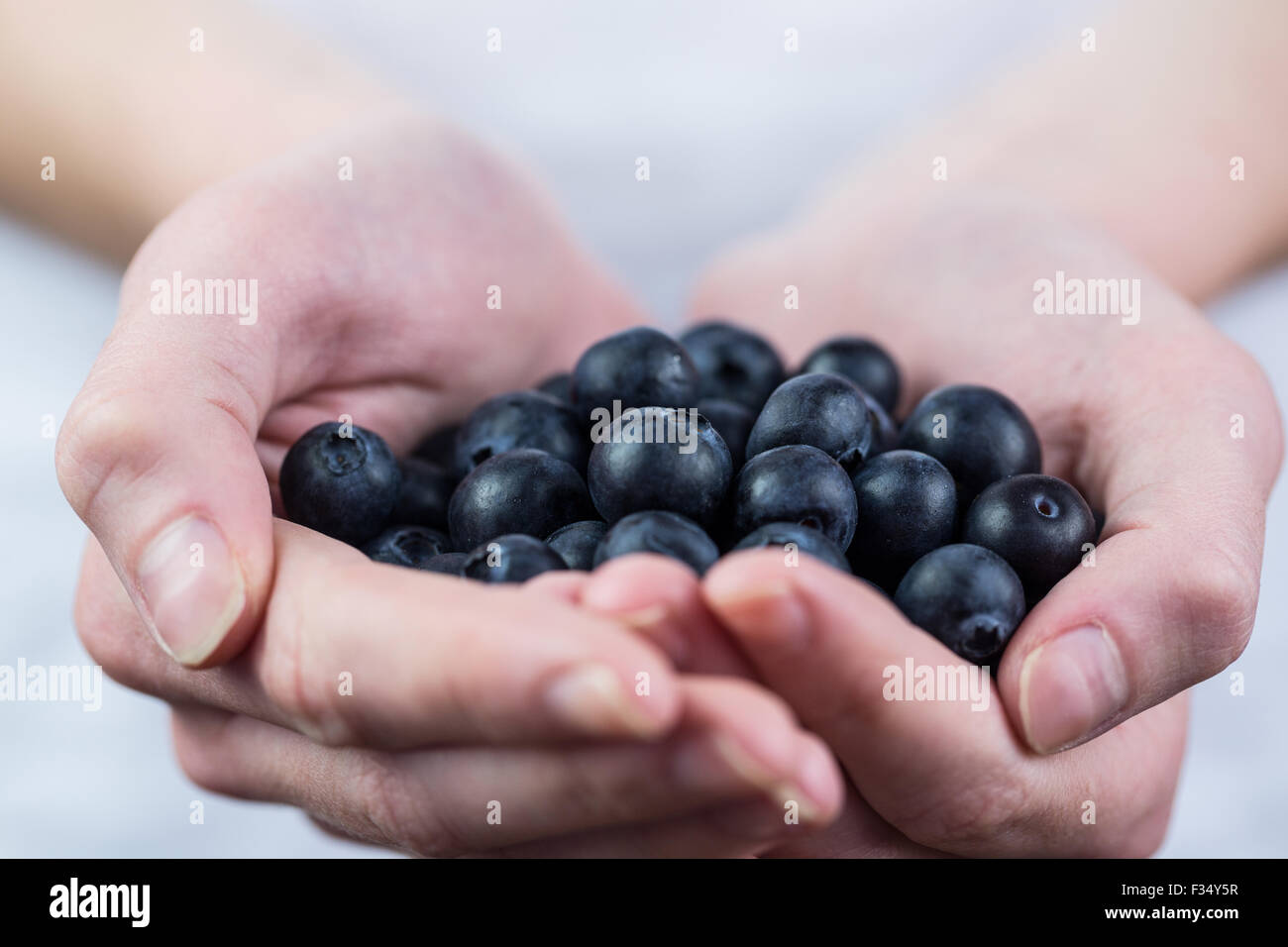 Woman showing handful of blueberries Stock Photo - Alamy