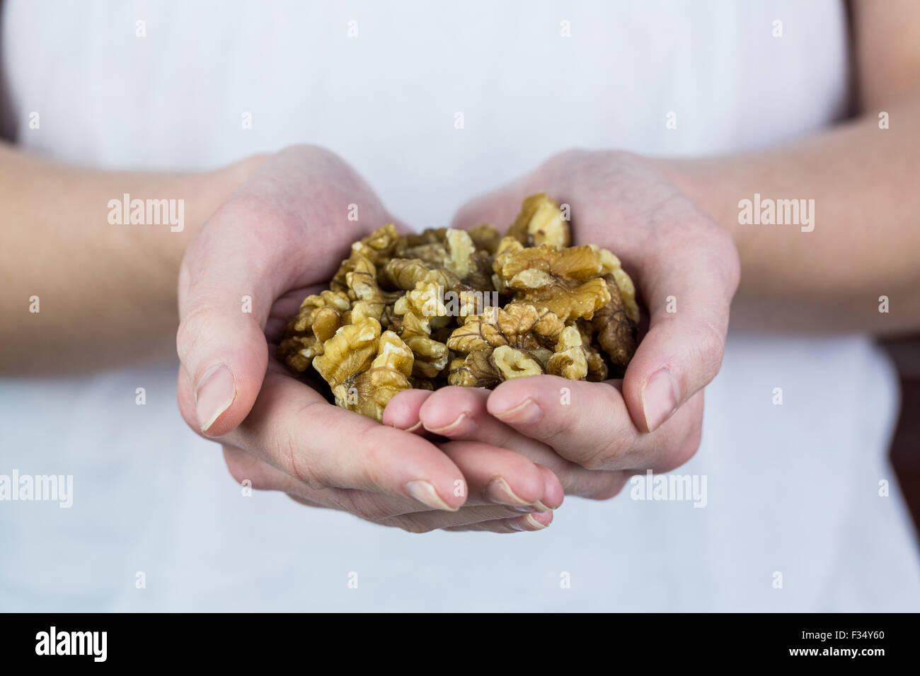 Woman showing handful of walnuts Stock Photo - Alamy