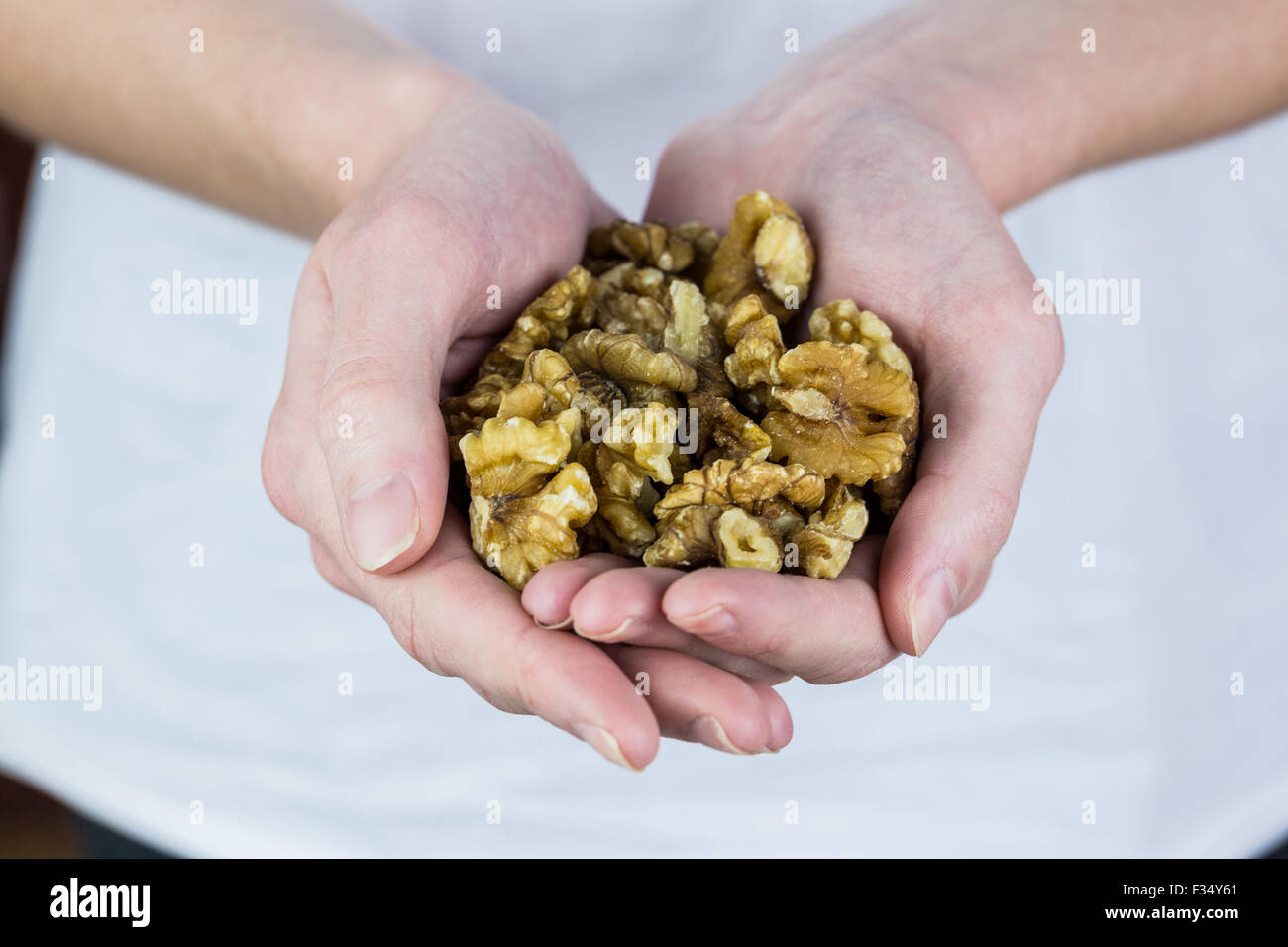 Woman showing handful of walnuts Stock Photo - Alamy