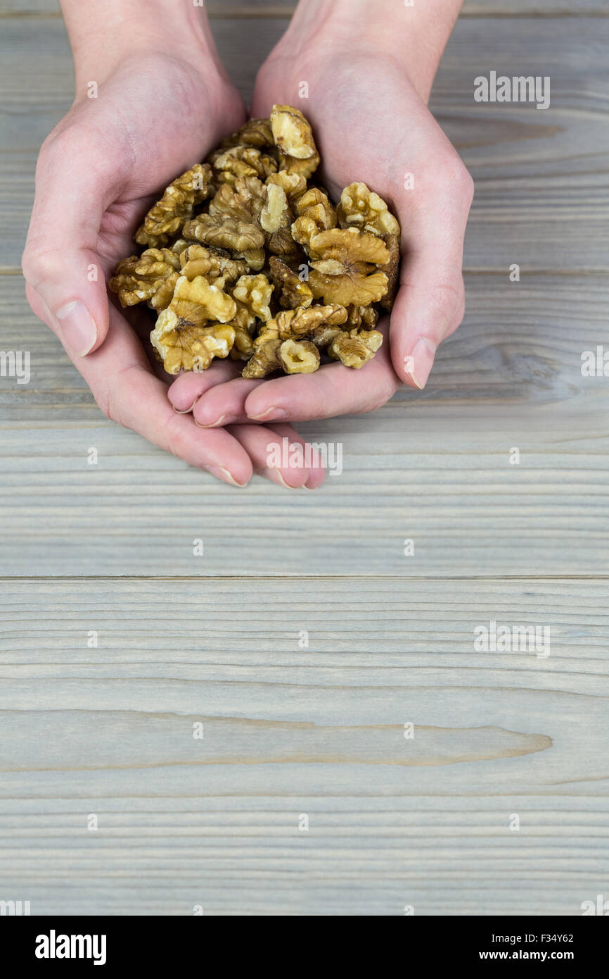 Woman showing handful of walnuts Stock Photo - Alamy
