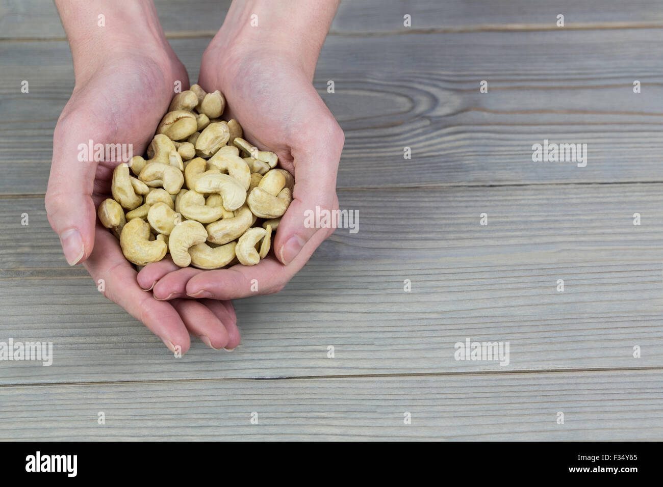 Woman showing handful of cashews Stock Photo - Alamy