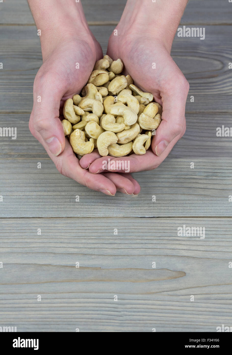Woman showing handful of cashews Stock Photo - Alamy