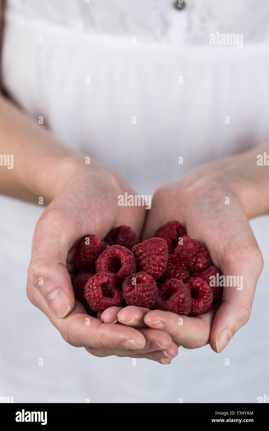 Woman showing handful of raspberries Stock Photo - Alamy