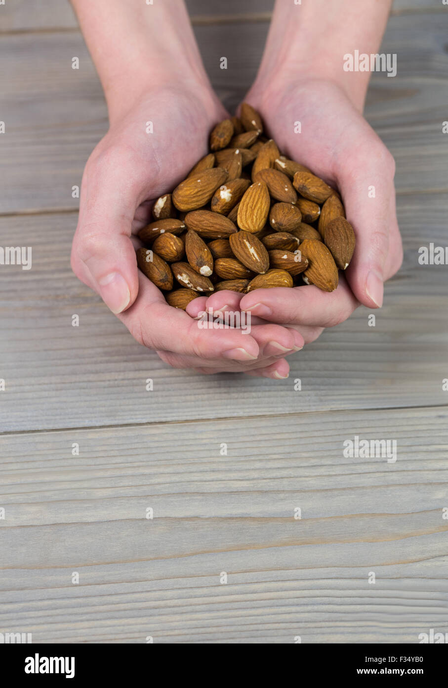 Woman showing handful of almonds Stock Photo - Alamy