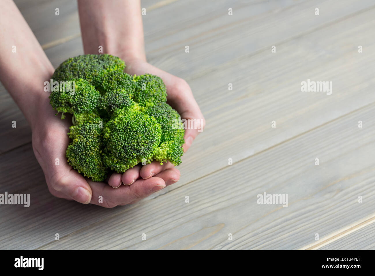 Woman showing fresh green brocolli Stock Photo - Alamy