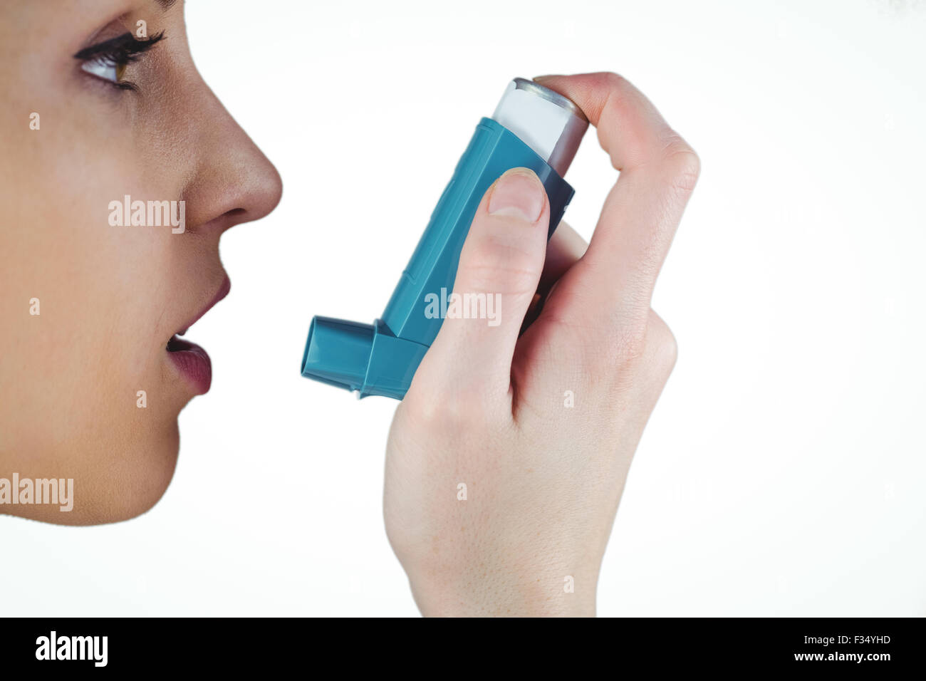 Asthmatic brunette using her inhaler Stock Photo - Alamy