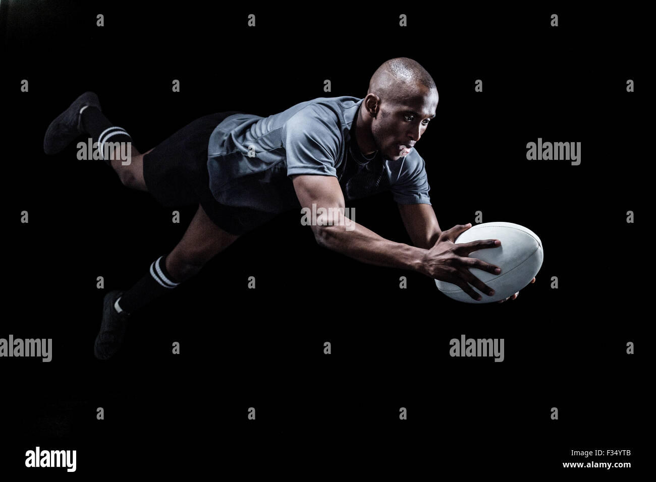 Sportsman jumping for catching rugby ball Stock Photo - Alamy