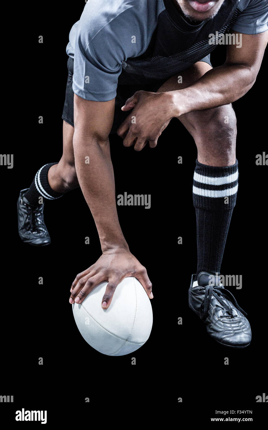 Low section of rugby player holding ball Stock Photo - Alamy