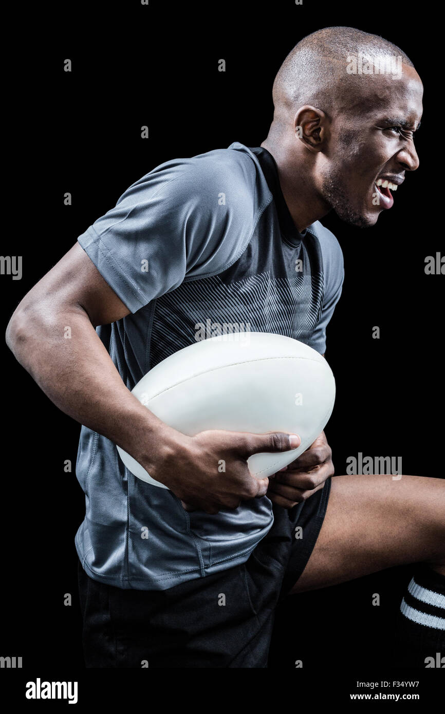 Aggressive sportsman with ball while playing rugby Stock Photo - Alamy