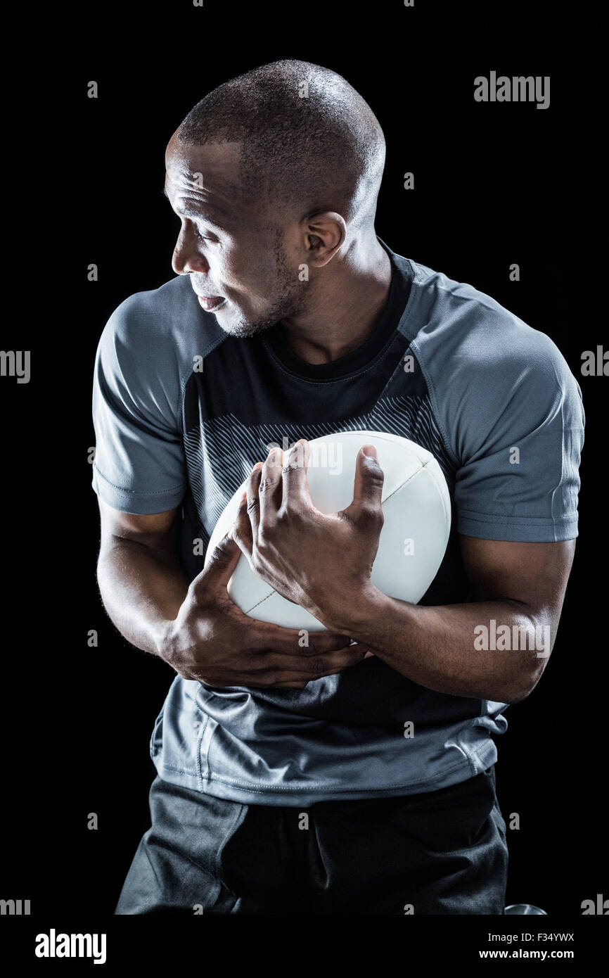 Rugby player looking away while catching ball Stock Photo - Alamy