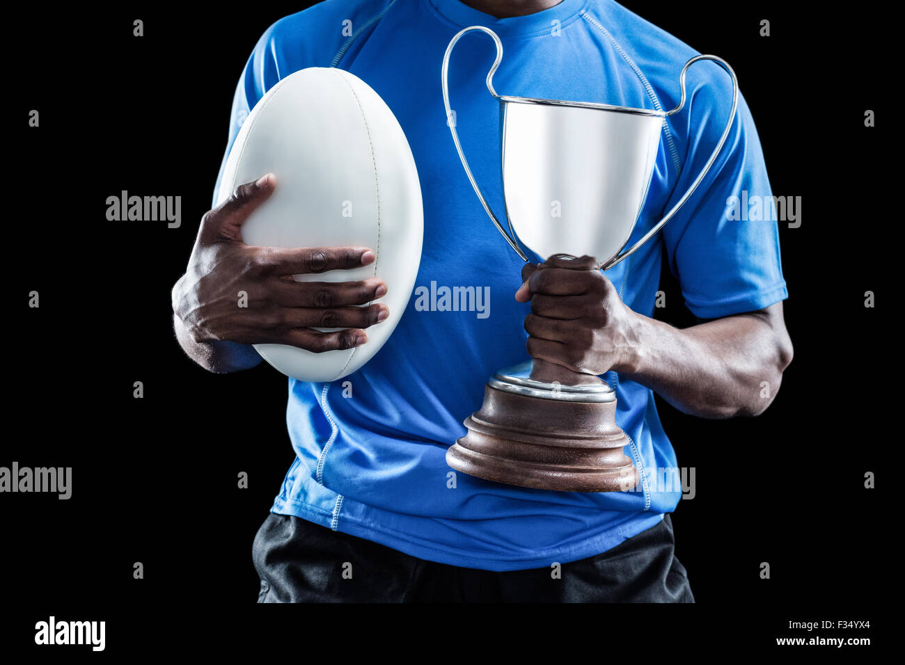 Mid section of sportsman holding trophy and rugby ball Stock Photo - Alamy