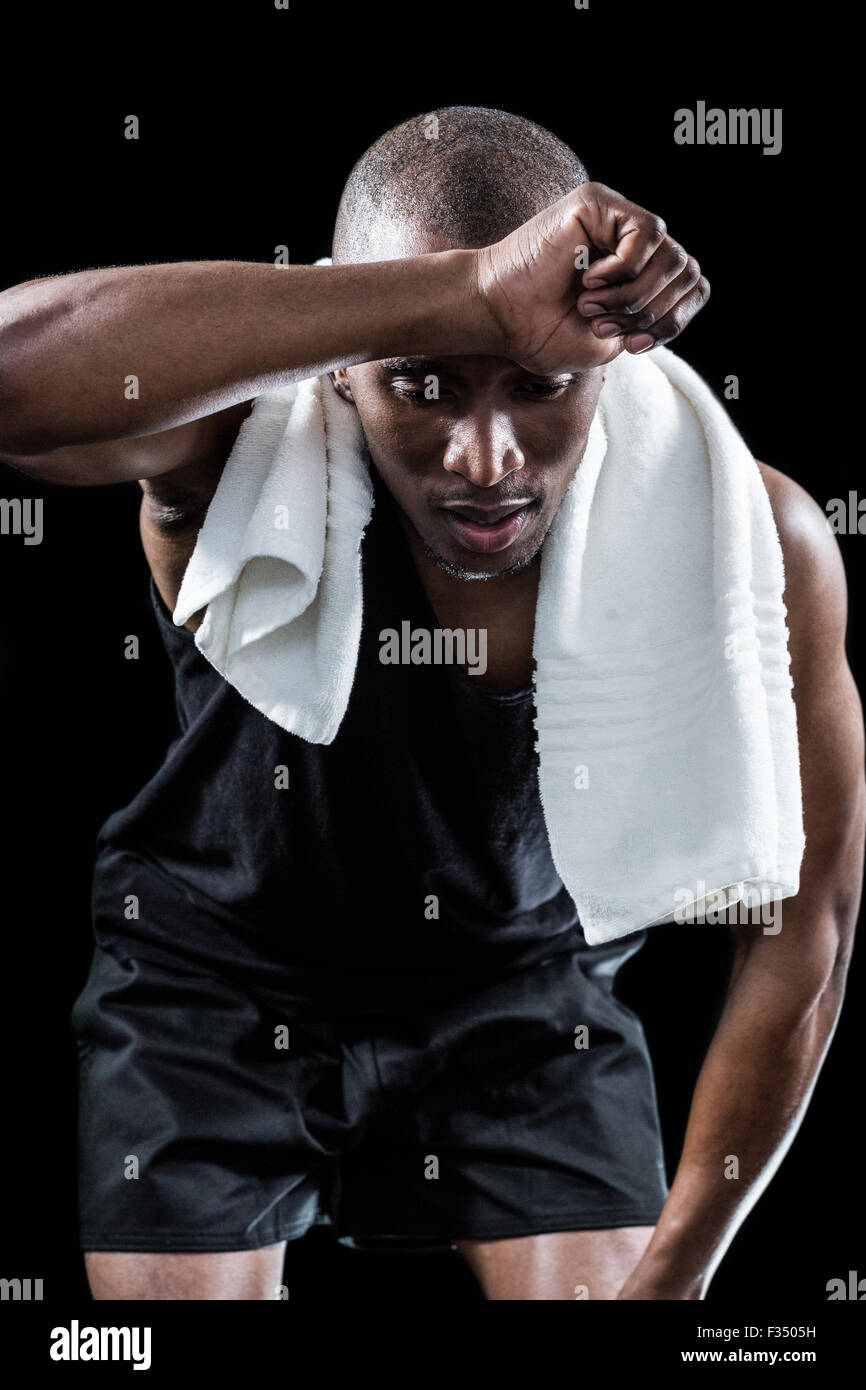 Athlete wiping sweat with hands while bending Stock Photo - Alamy