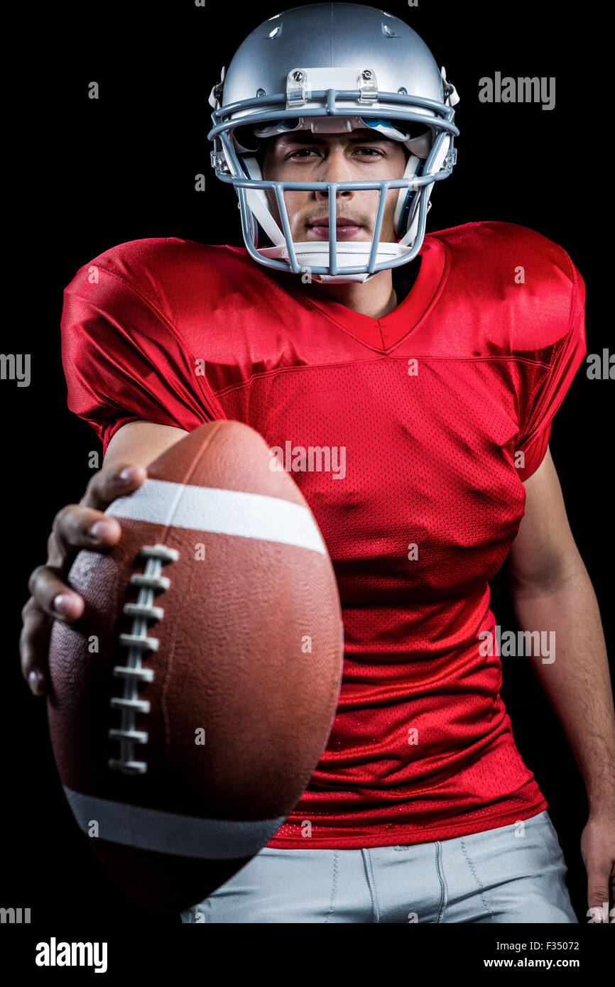 Portrait of determined American football player showing ball Stock ...