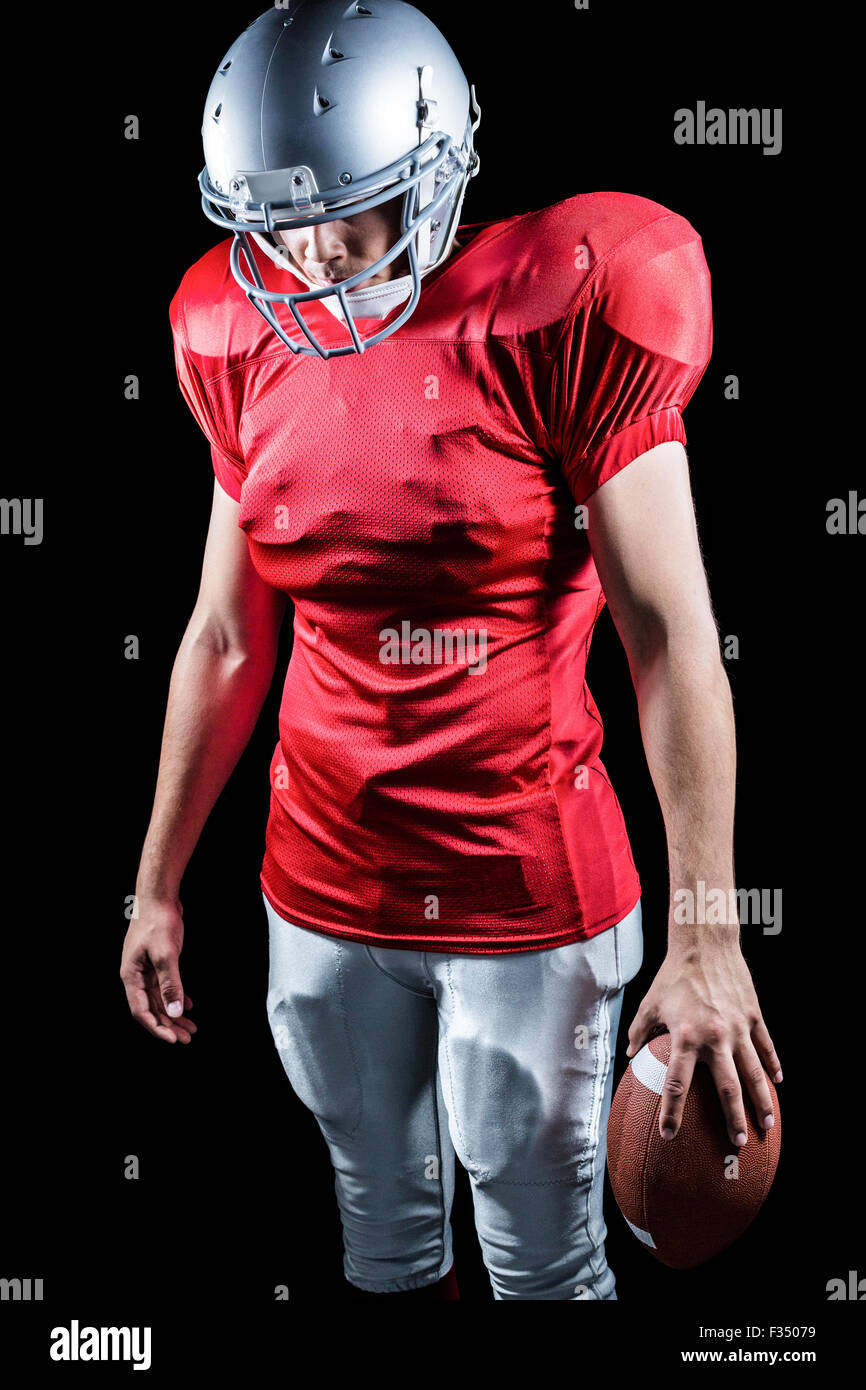 American football player looking down while standing Stock Photo - Alamy