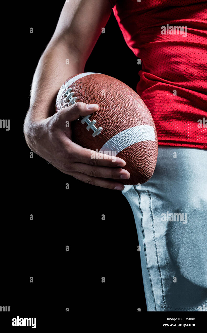 Cropped image of sportsman holding American football Stock Photo - Alamy