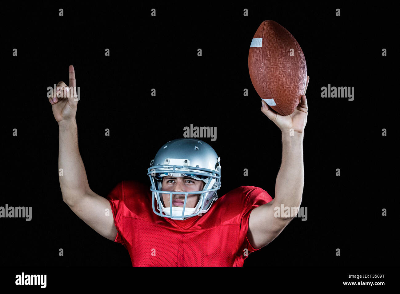 American football player with arms raised holding ball Stock Photo - Alamy