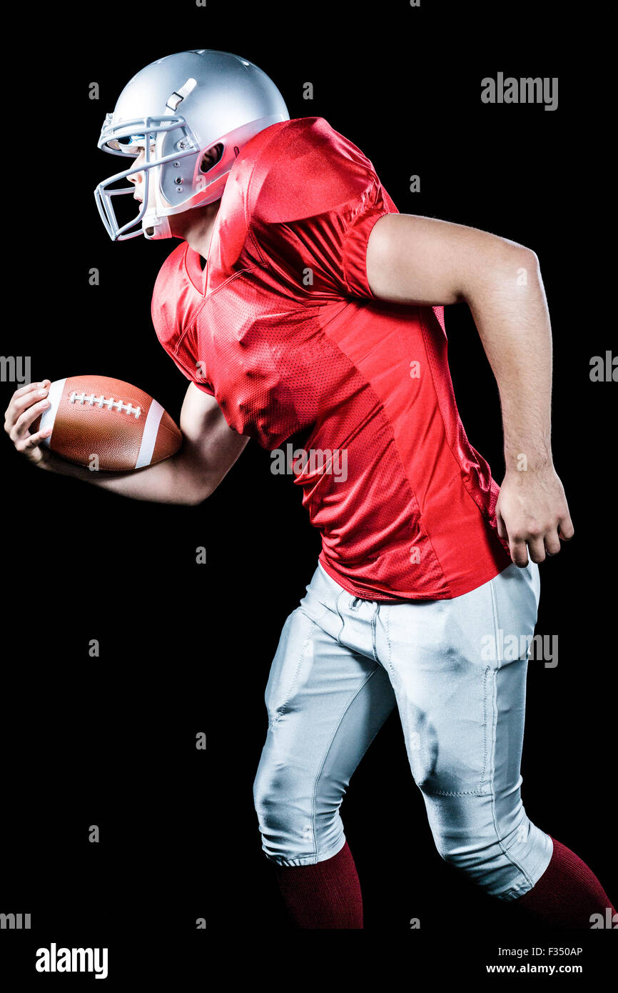 Side view of sportsman running while playing American football Stock ...