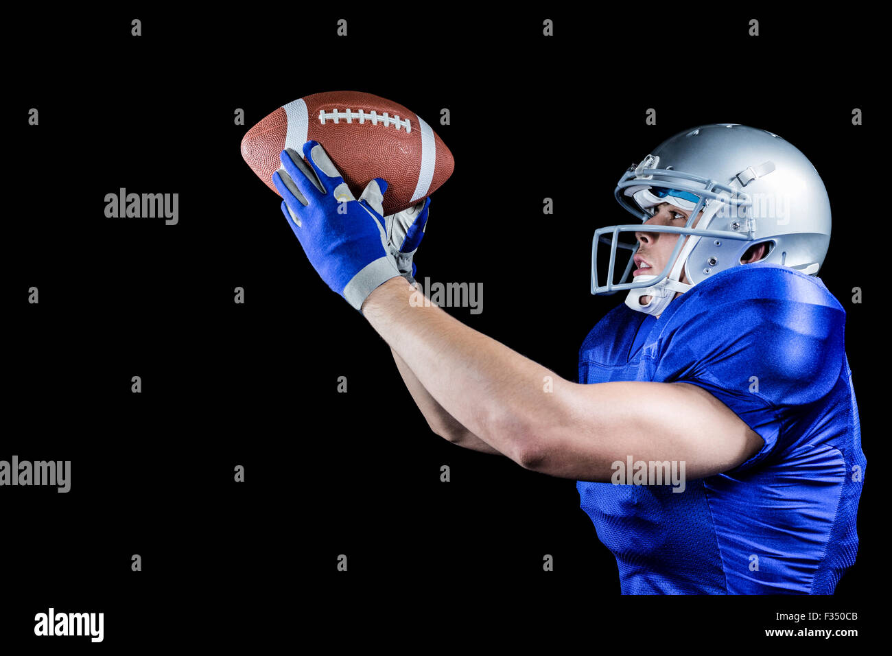 Side view of American football player looking at ball Stock Photo - Alamy