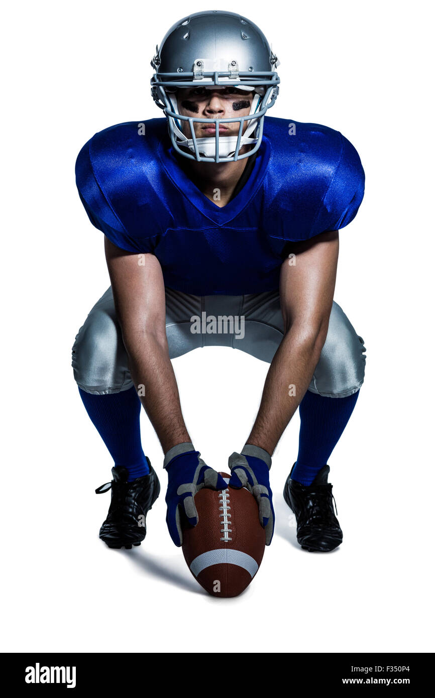 American football player with ball crouching Stock Photo - Alamy