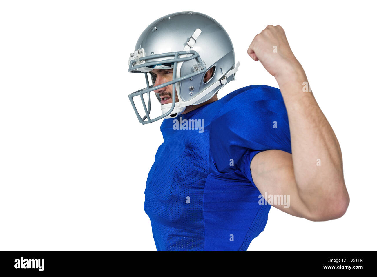 American football player looking away while flexing muscles Stock Photo ...