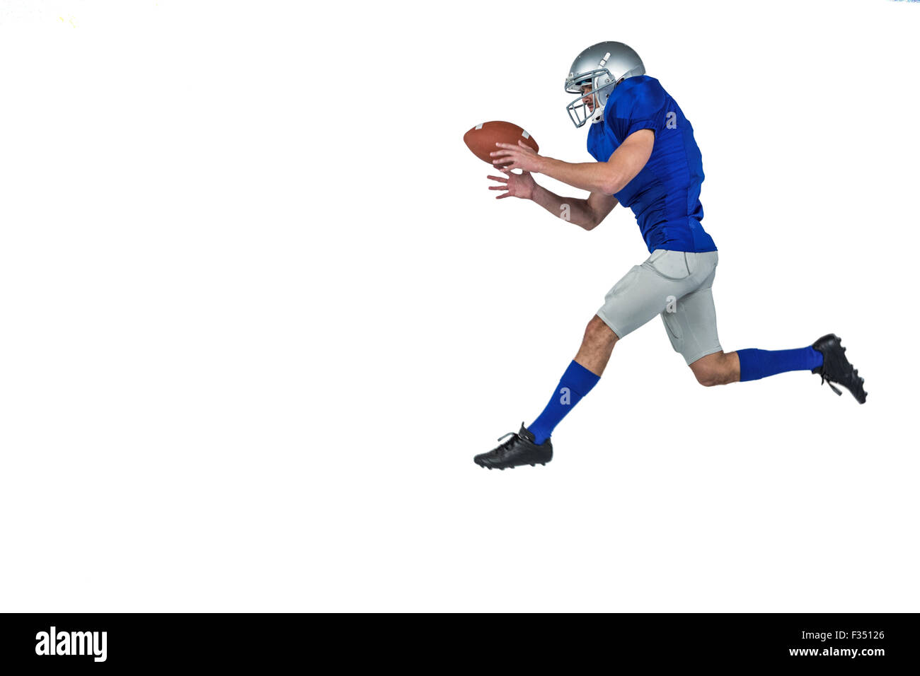 American football player running while catching ball Stock Photo - Alamy