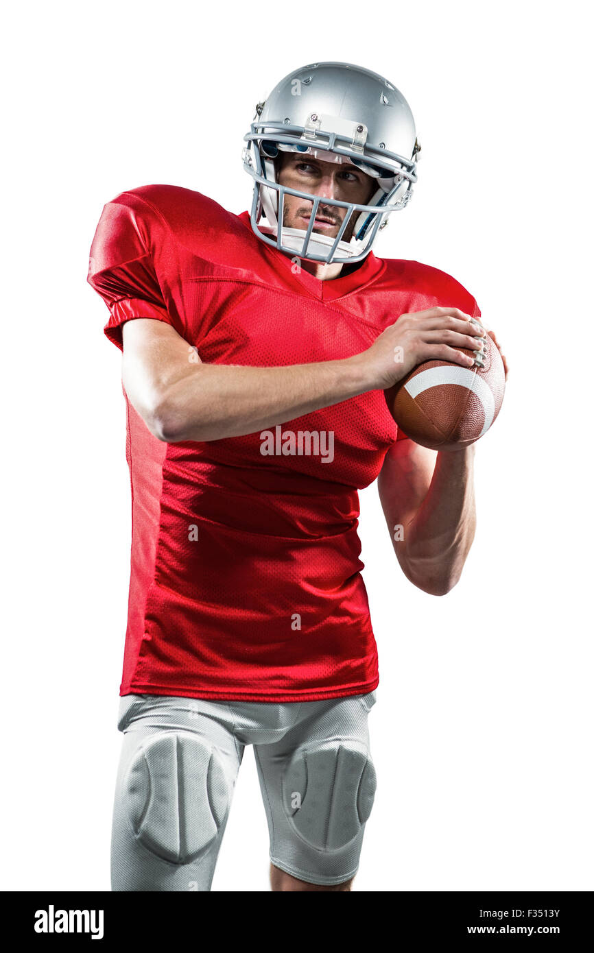 Confident American football player in red jersey holding ball Stock ...