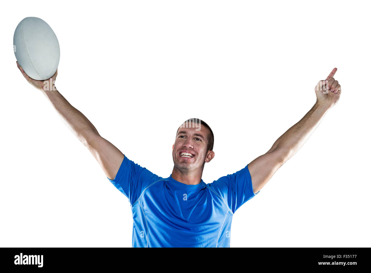 Happy rugby player in blue jersey holding ball with arms raised Stock ...