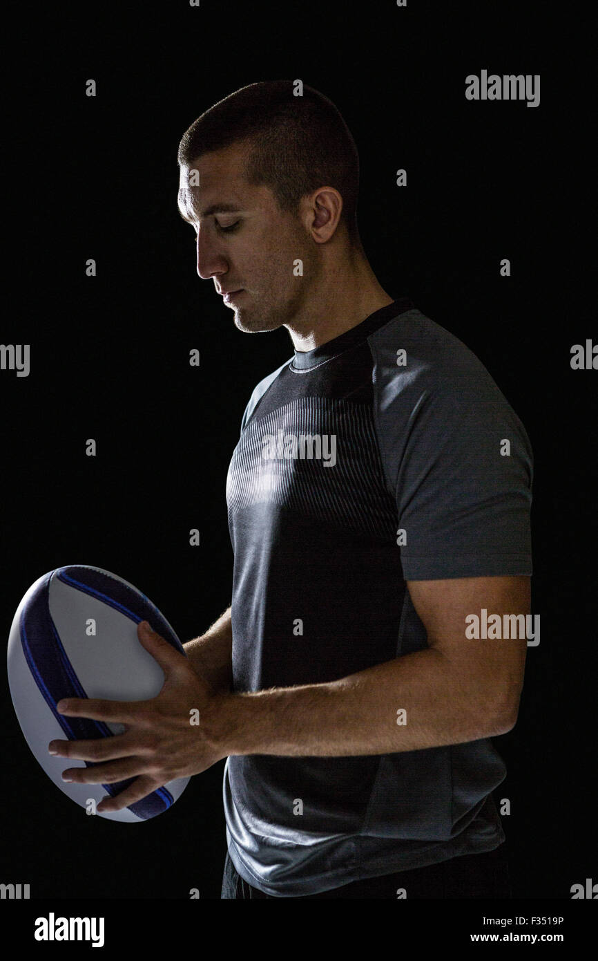Calm rugby player thinking while holding ball Stock Photo - Alamy