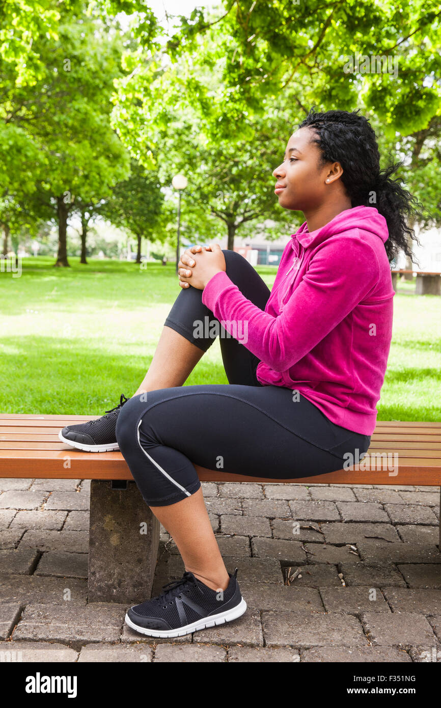 Fit woman sitting on bench Stock Photo - Alamy