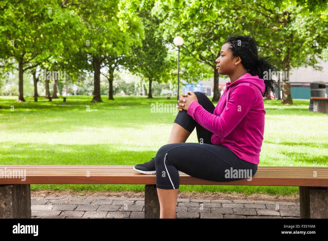 Fit woman sitting on bench Stock Photo - Alamy