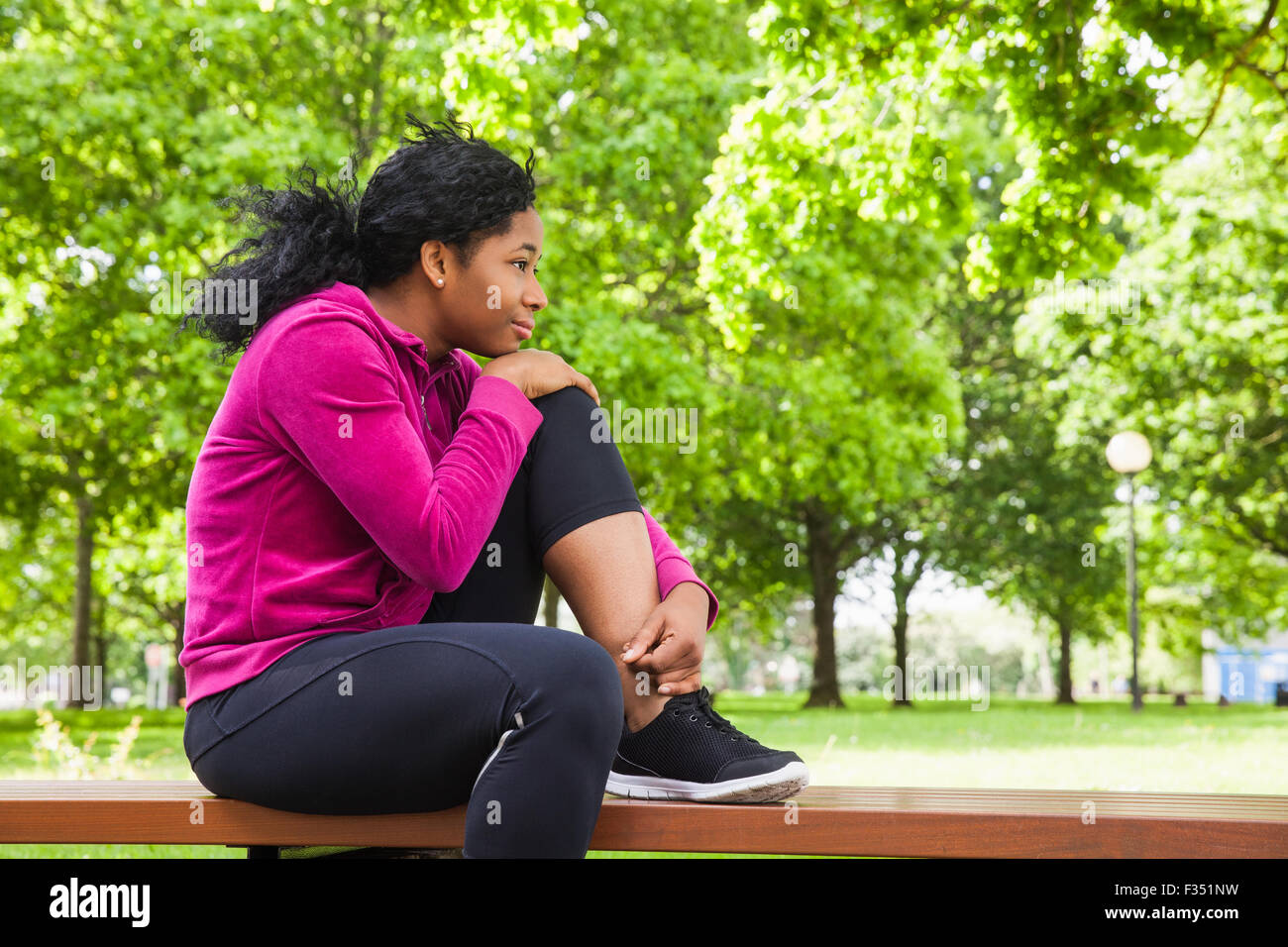 Fit woman sitting on bench Stock Photo - Alamy