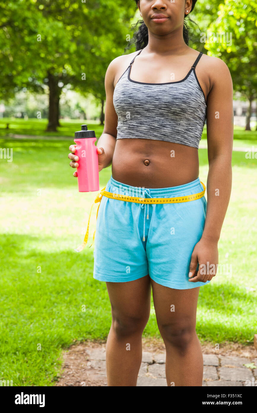 Fit woman measuring her waist Stock Photo - Alamy
