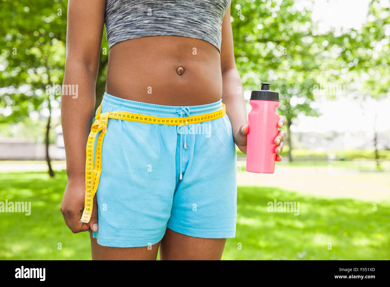 Fit woman measuring her waist Stock Photo - Alamy