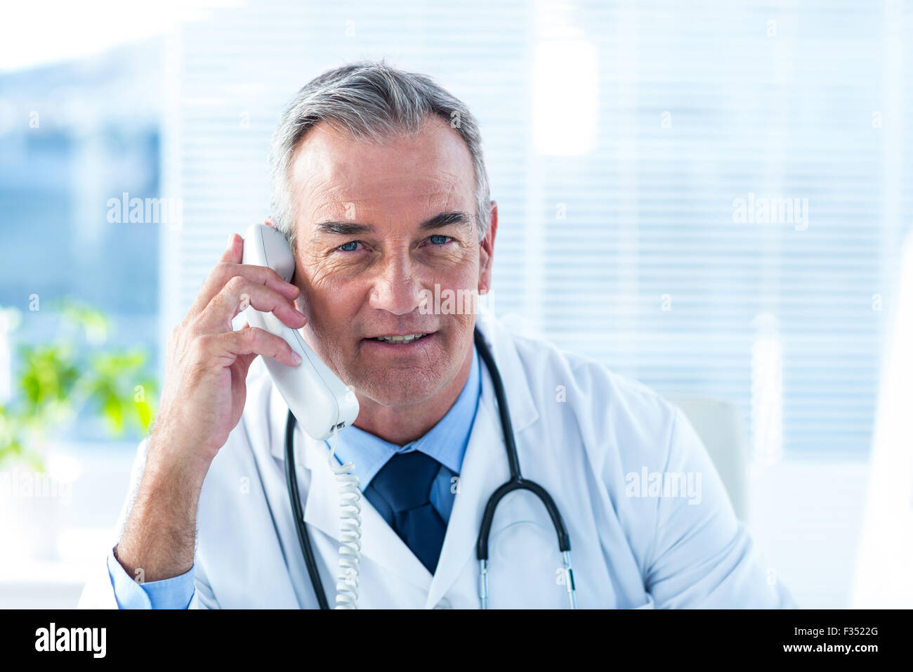 Male doctor sitting phone hi-res stock photography and images - Alamy