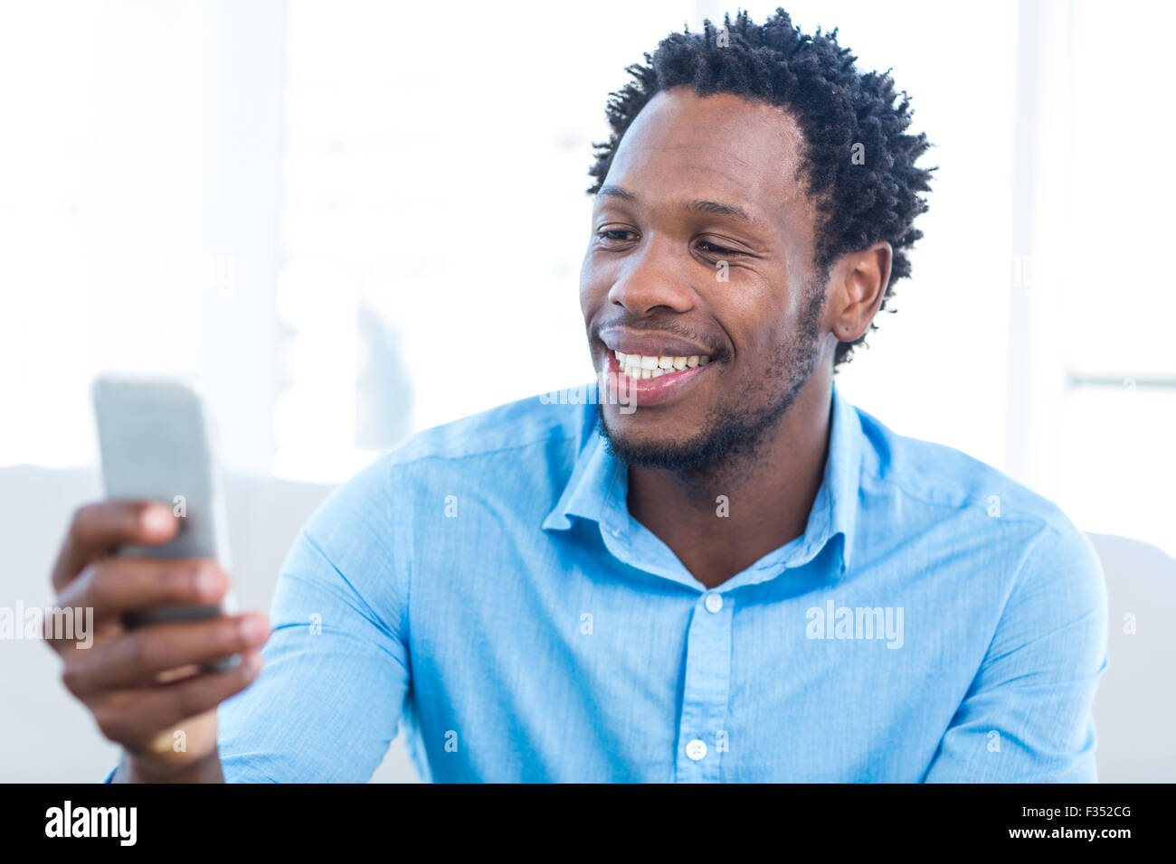 Happy man looking at mobile phone Stock Photo - Alamy